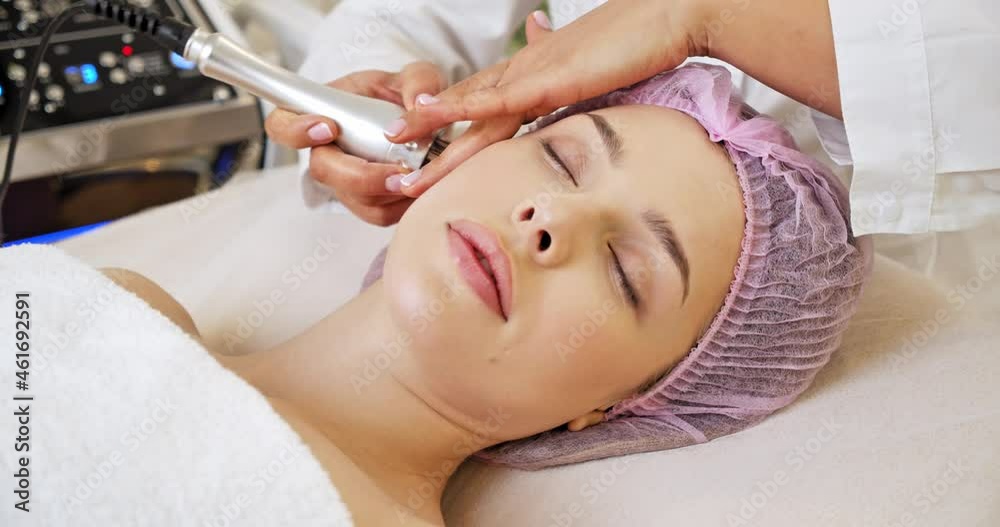Beautiful woman receiving facial microcurrent treatment at spa salon ...