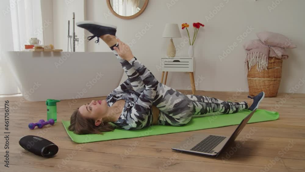 Charming active sporty fit woman lying on fitness mat, practicing ...