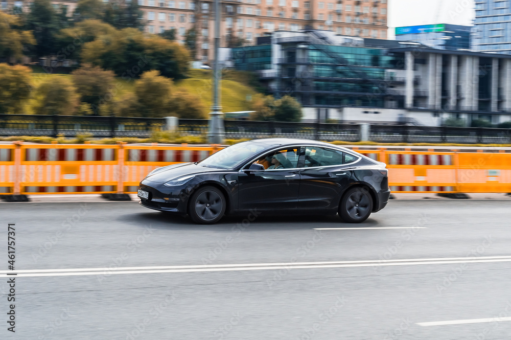 Tesla Model 3 on the city road. All-electric five-door liftback sedan ...