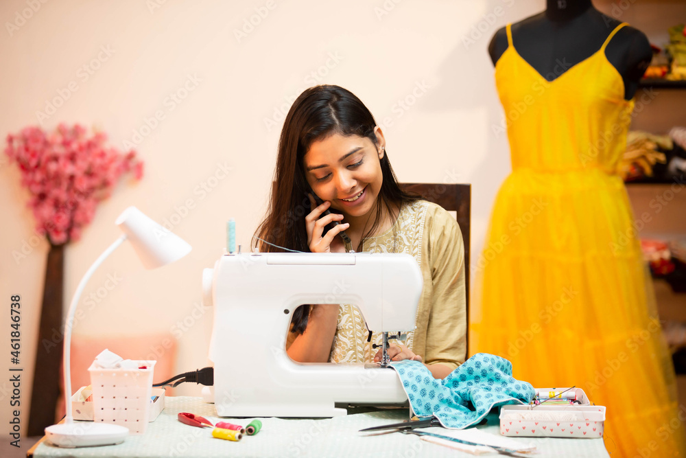 Young indian happy woman,tailor,fashion designer,using sewing machine ...