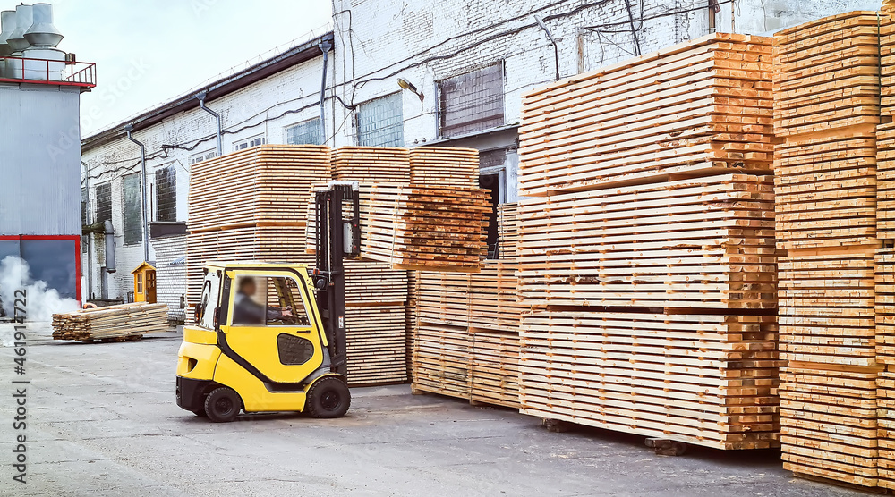 Forklift loads lumber into stacks at the finished product warehouse ...