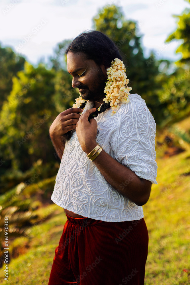 portrait of dark skinned Indian non-binary individual with traditional ...
