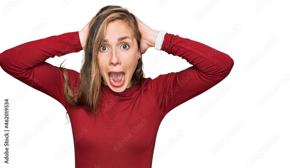 Young blonde woman wearing casual clothes crazy and scared with hands ...