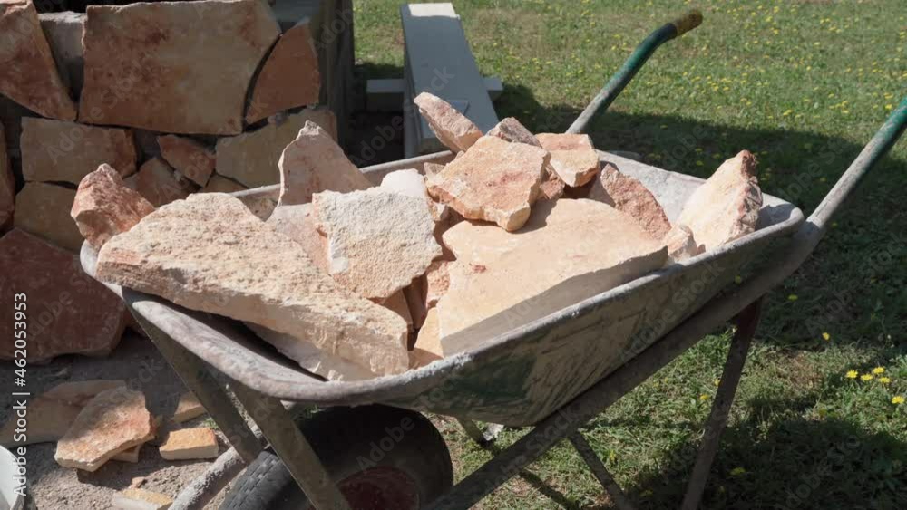 Vídeo do Stock: Industrial wheelbarrow with orange rock stones prepared ...