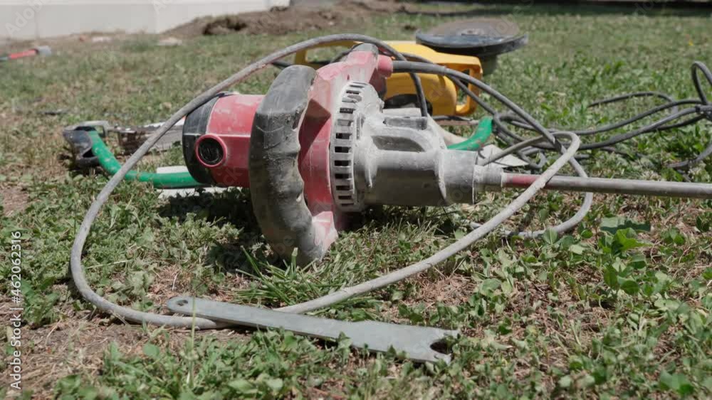 Working tools on construction site, electric cement mixer with whisk ...