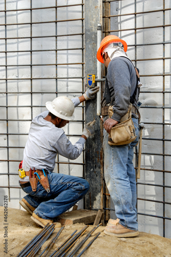 Workers using a laser level on retaining wall steel post Stock Photo ...