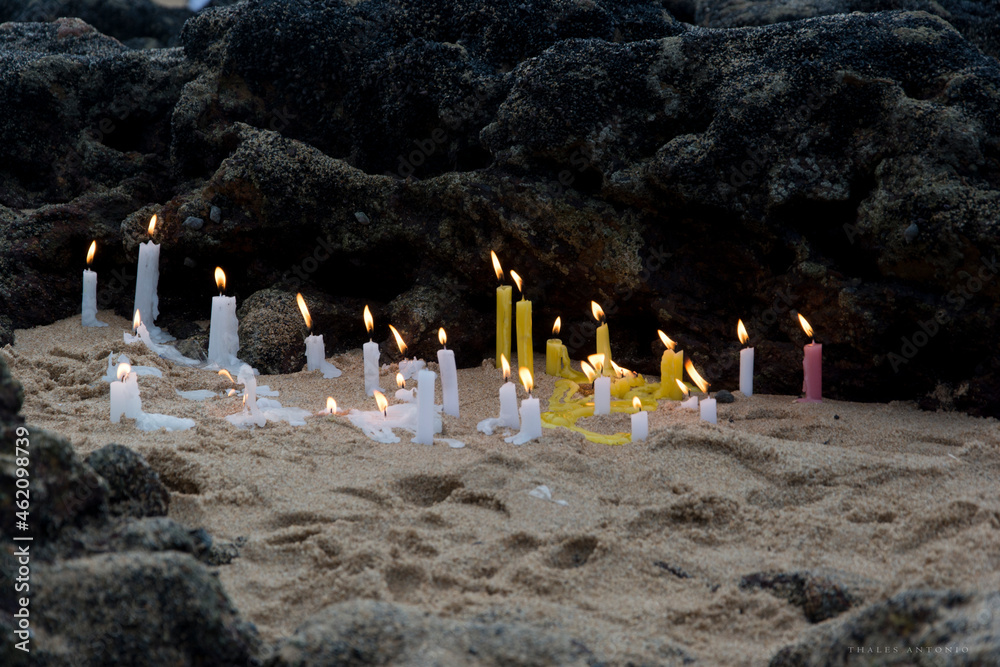 White and yellow candles lit in the sand by members of the candomble ...