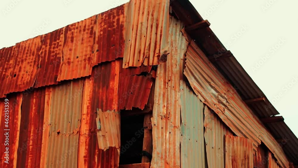 Flimsy walls of a shanty tin house being blown away buy the breeze ...