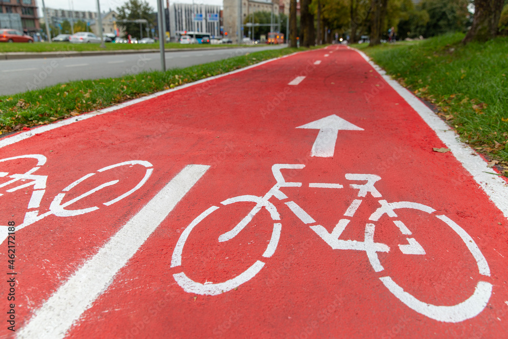traffic, road marking and city concept - red bike lane with signs of ...
