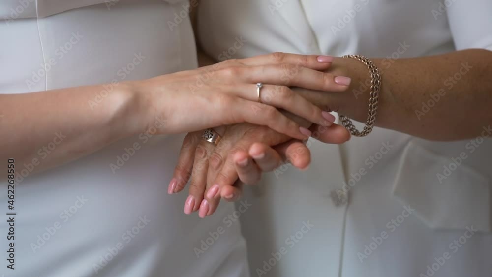 Female hands close-up. The adult daughter gently holds her mother's ...