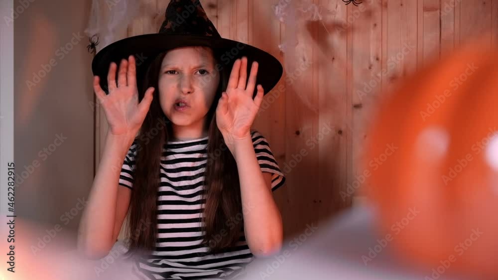 Little pretty girl witch in black wizard hat says Boo with scary ...