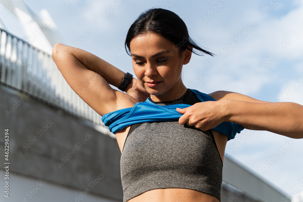 Woman Putting On Shirt