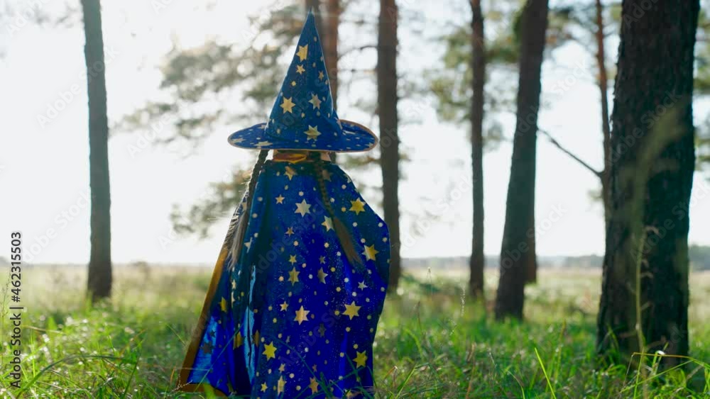 Vídeo do Stock: Child fantasizes in mantle of magician in forest. A ...