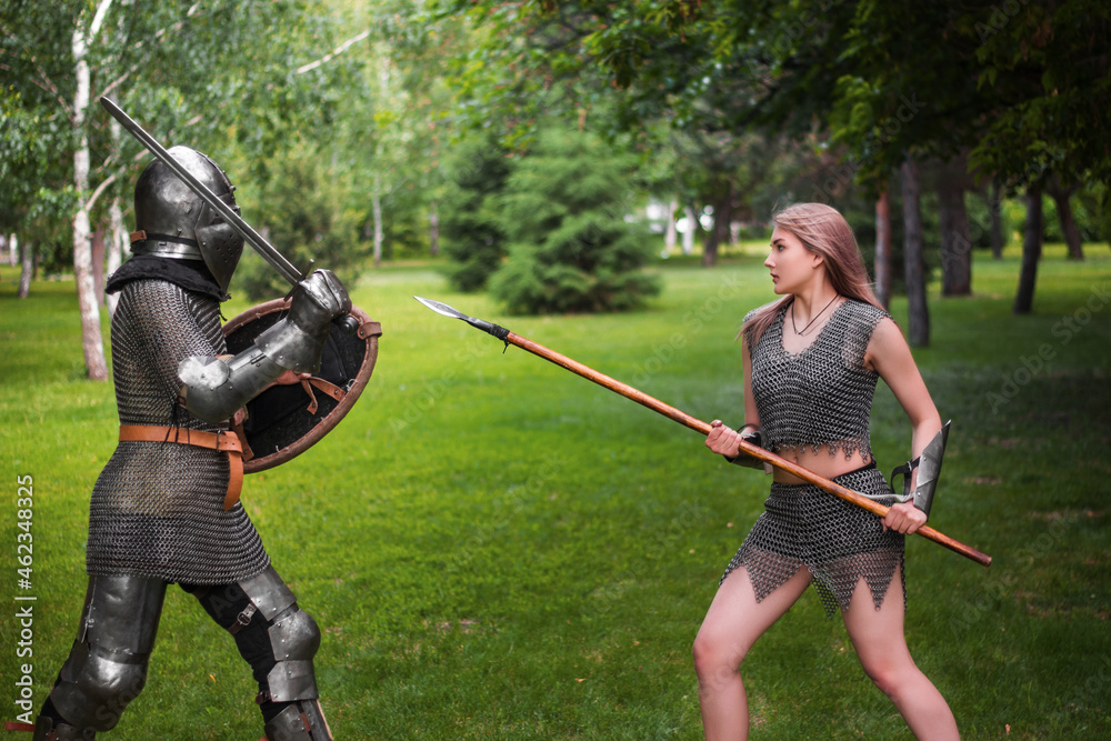 Battle of a fantasy warrior girl and a medieval knight in full set ...