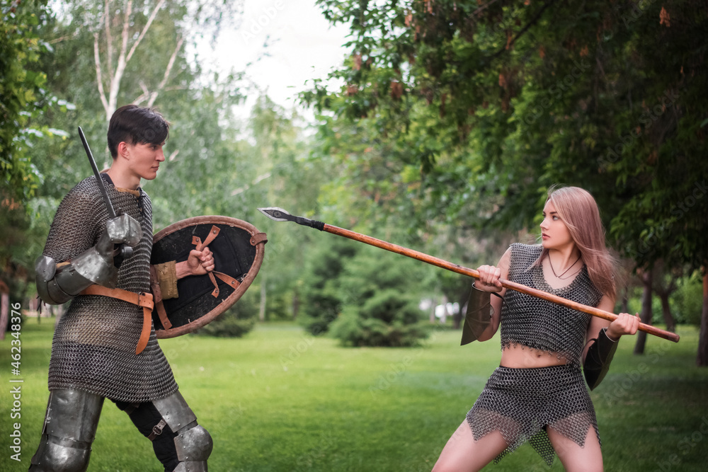 Battle of a fantasy warrior girl and a medieval knight in full set ...