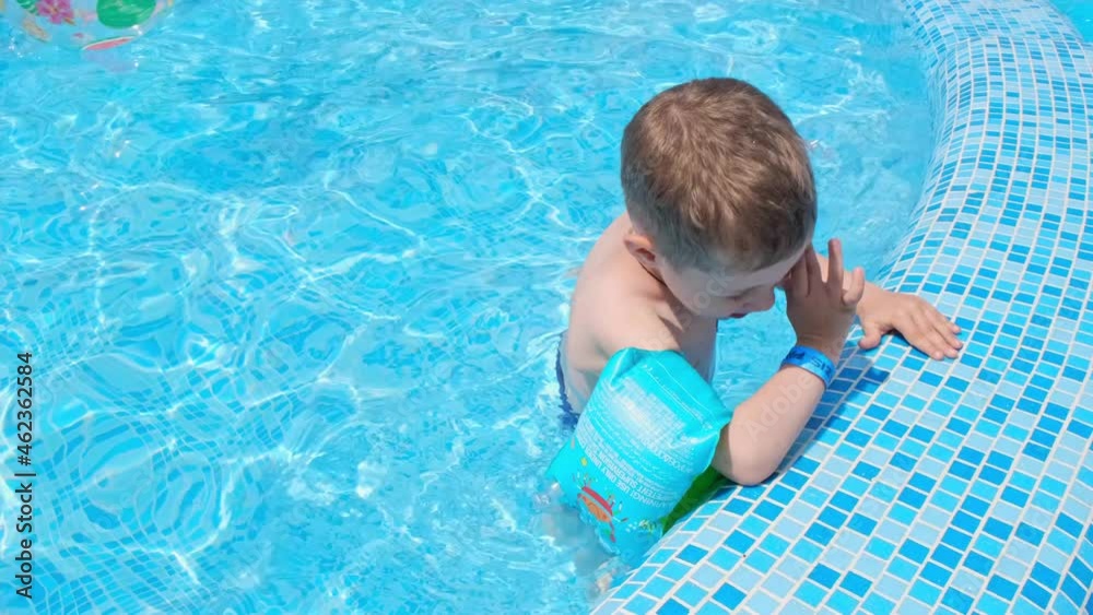 Happy child playing in swimming pool. Summer. Young boy kid child is ...