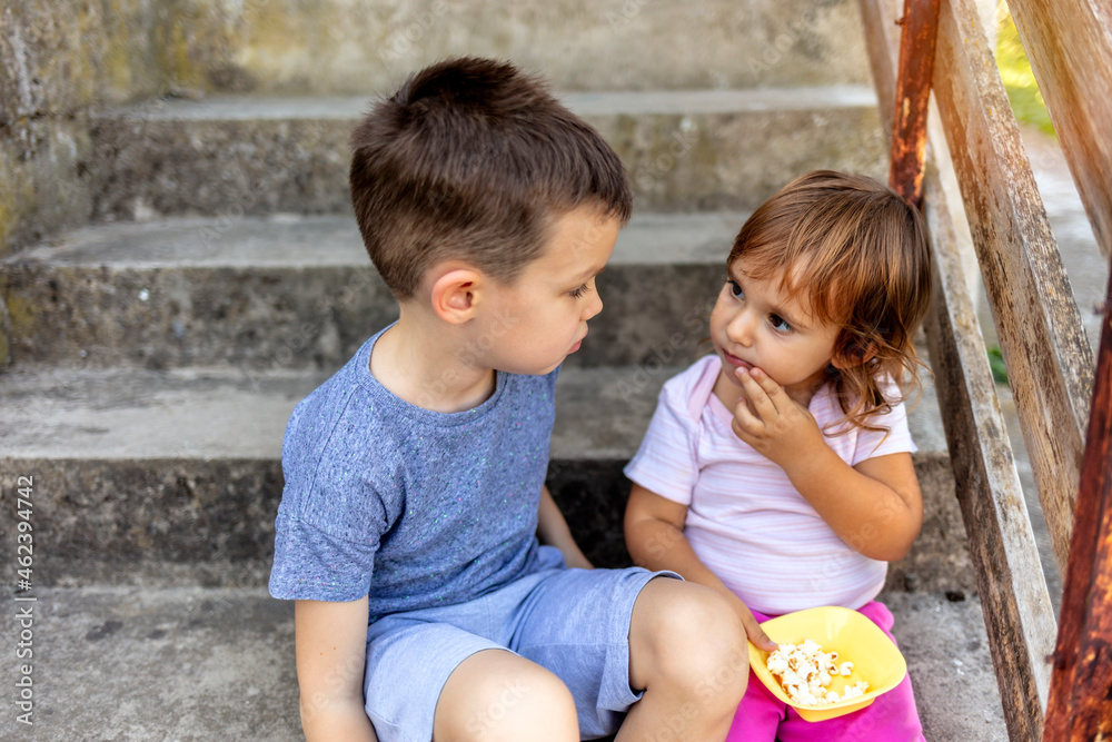 Cropped shot of a cute little girl sharing a dish of popcorn with her ...