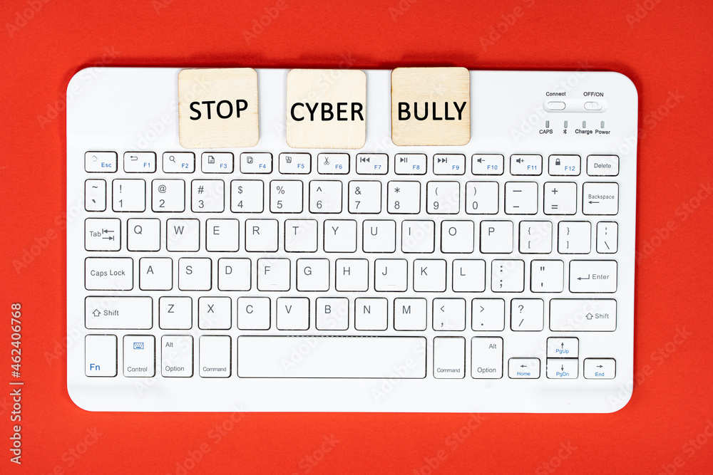 Layout of a keyboard and wooden tiles with texts STOP CYBER BULLY ...