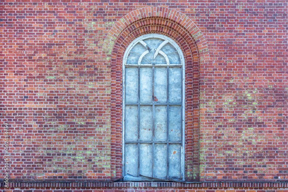 Arched window opening with an old wooden frame on the background of an ...