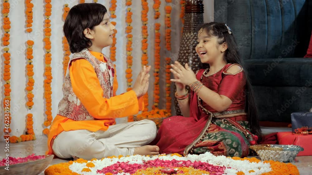 Happy siblings playing a hand-clap game together while sitting on the ...