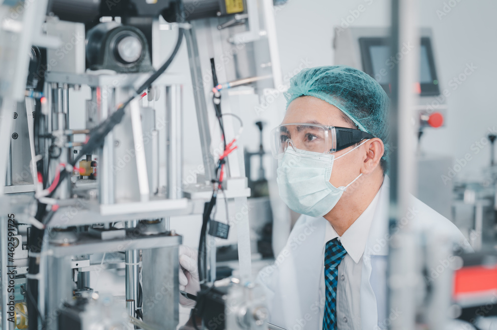 Both male and female Asian scientists are outfitted with protective ...