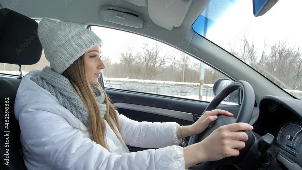 Winter road trip. Profile of a young beautiful girl driver, a young ...