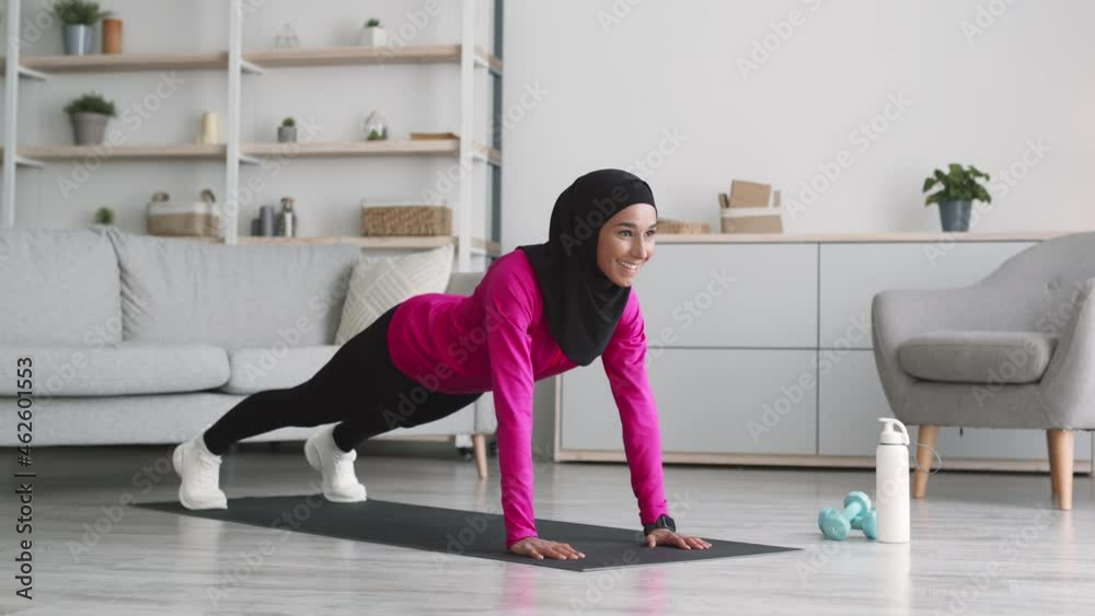 Strength workout at home. Young active muslim woman in hijab practicing ...
