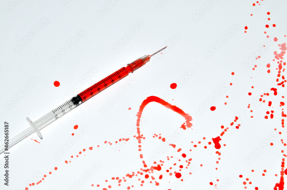 Foto de Syringe witn Drops of blood staining spots on a white ...
