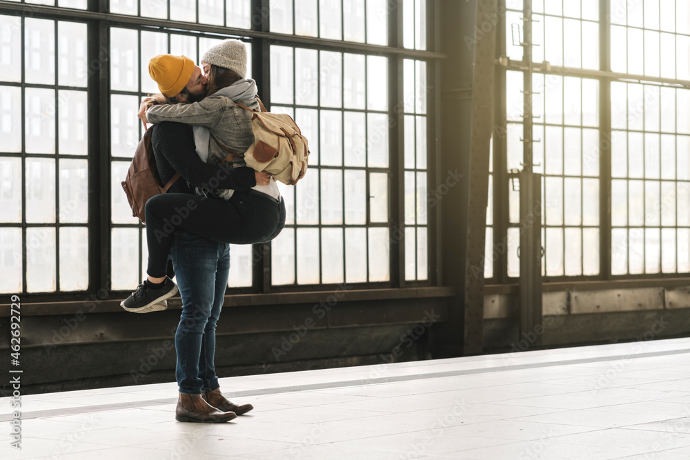Affectionate young couple kissing at the station platform, Berlin ...