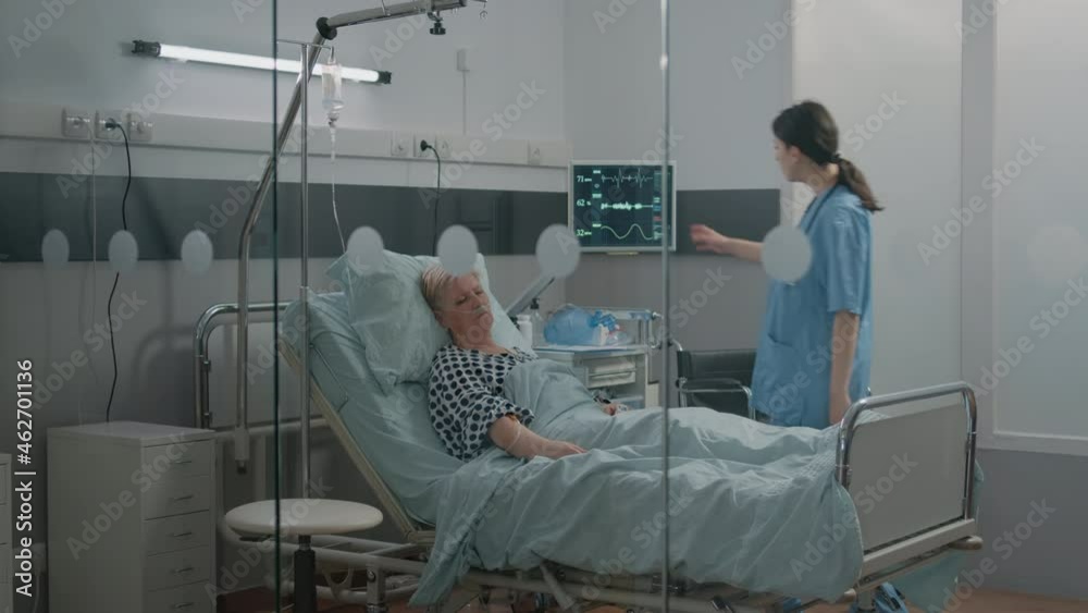 Woman nurse checking up on sleeping old patient in bed for healthcare ...