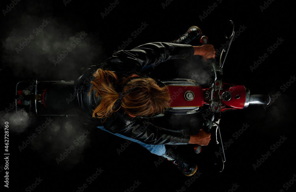 Top view of woman on vintage motorcycle with black background and smoke ...