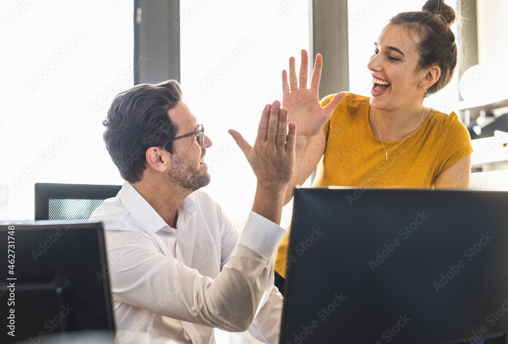 Business people giving high five while working together st office Stock ...