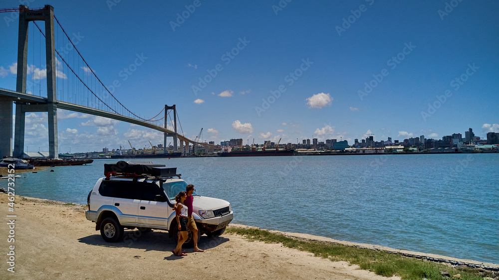 Mozambique, Katembe, Adult couple standing by 4x4 car admiring view of ...