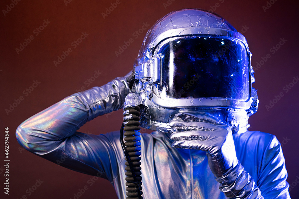 Astronaut wearing silver space helmet against colored background Stock ...