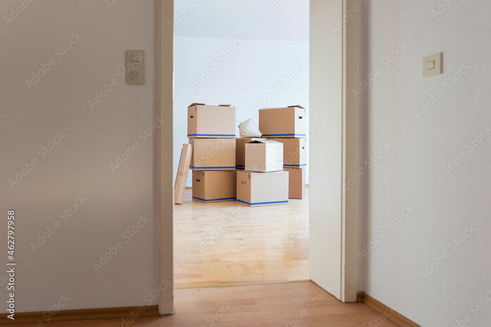 Cardboard boxes in an empty room in a new home Stock Photo | Adobe Stock