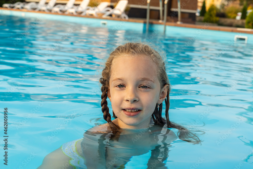 Portrait of a girl swimming in swimming pool Stock Photo | Adobe Stock