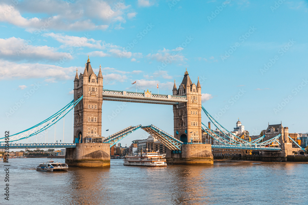 Paddle steamer boat moving under lifted Tower Bridge, London, England ...