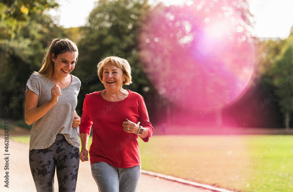 Granddaughter and grandmother having fun, jogging together in the park ...