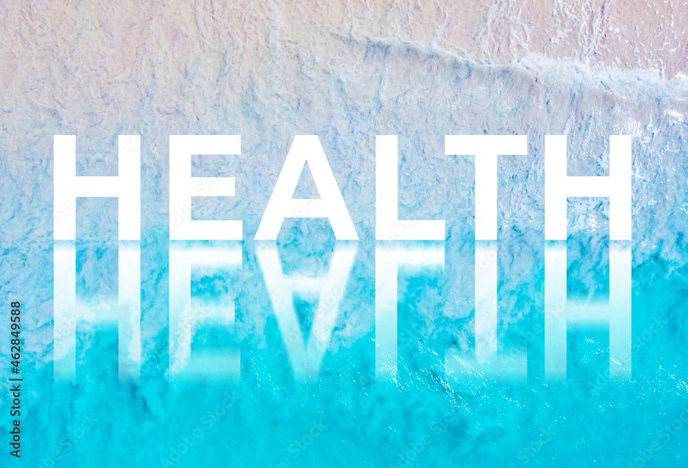 The word HEALTH written by the ocean with a wave on the beach ...
