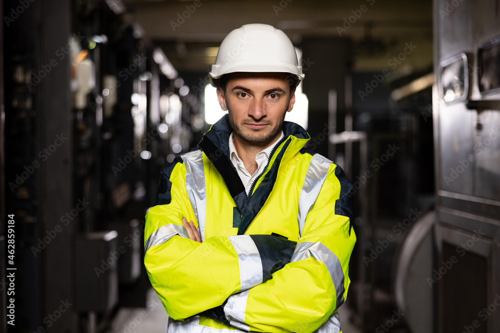 Young factory engineer or worker wearing safety vest and hard hat ...