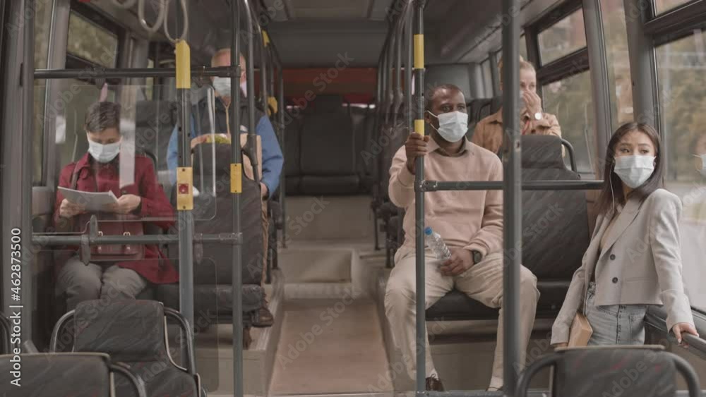 Multiethnic people wearing masks riding public transport, senior ...