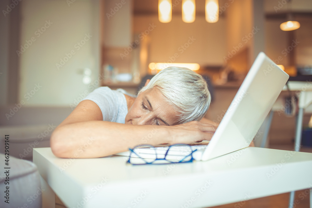 Mature businesswoman sleeping at workplace. Shot of a mature ...