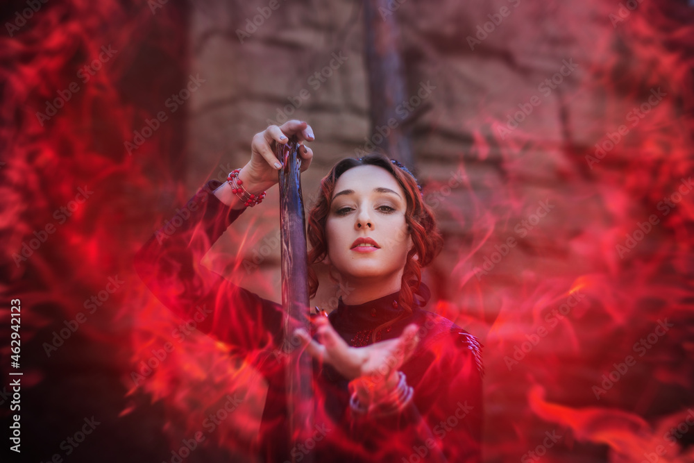 Evil witch with a staff in the forest. Slavic witch creates red magic ...