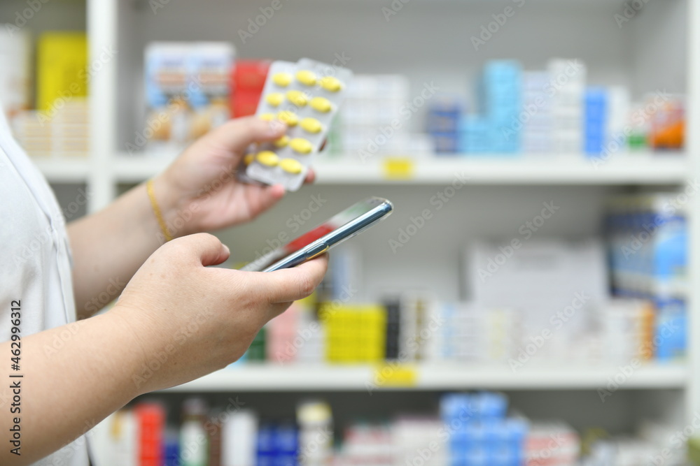 Pharmacist holding capsule pack and mobile smart phone for search bar ...
