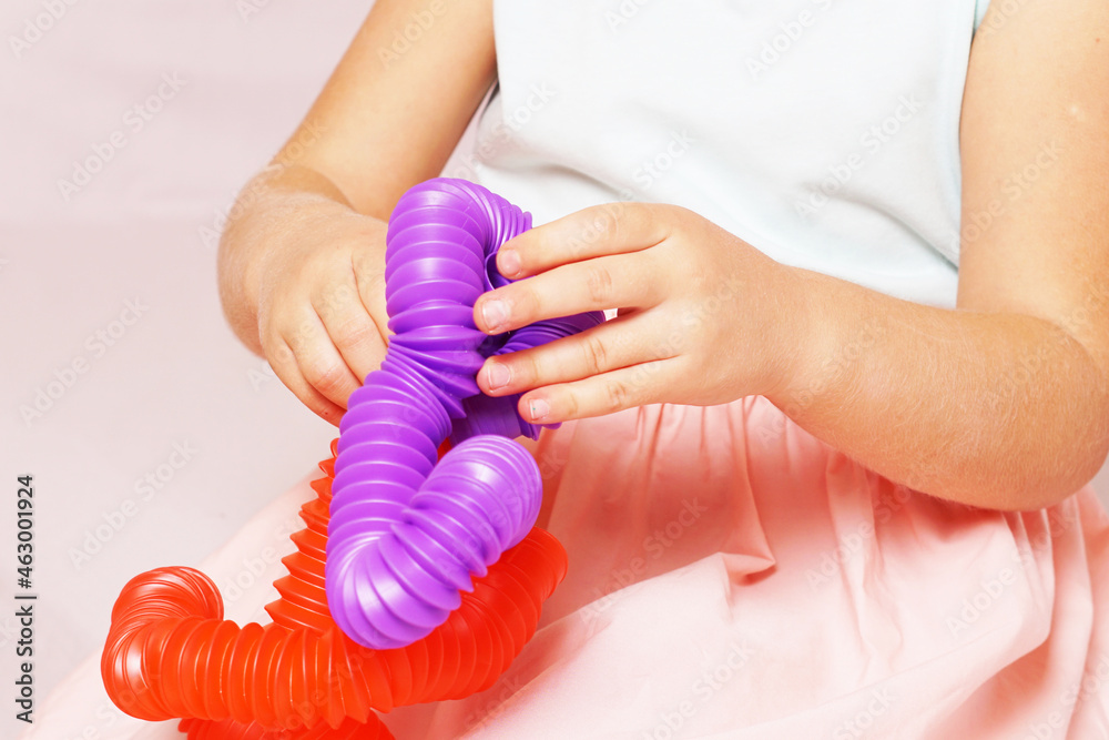 The child plays a pop tube of different colors. Pop tube yellow, purple ...