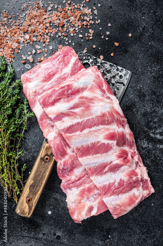 Uncooked Raw pork spare ribs on butcher meat cleaver. Black background ...