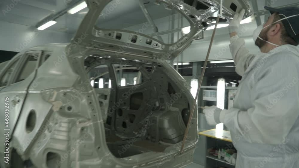 Checkman are checking assembling of car bodies before painting process ...