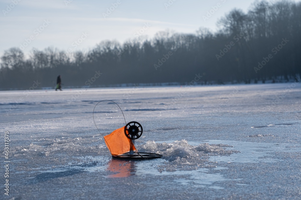 predator tip-up fishing rod with orange signal flag in misty backlight ...