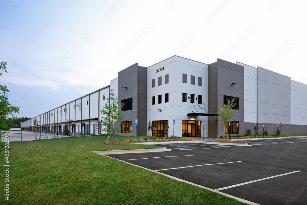 Modern gray industrial warehouse distribution building and parking lot ...