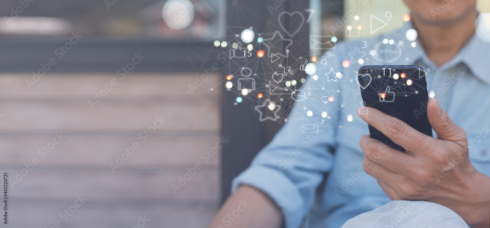 Man using mobile phone at home with social media apps icons on virtual ...